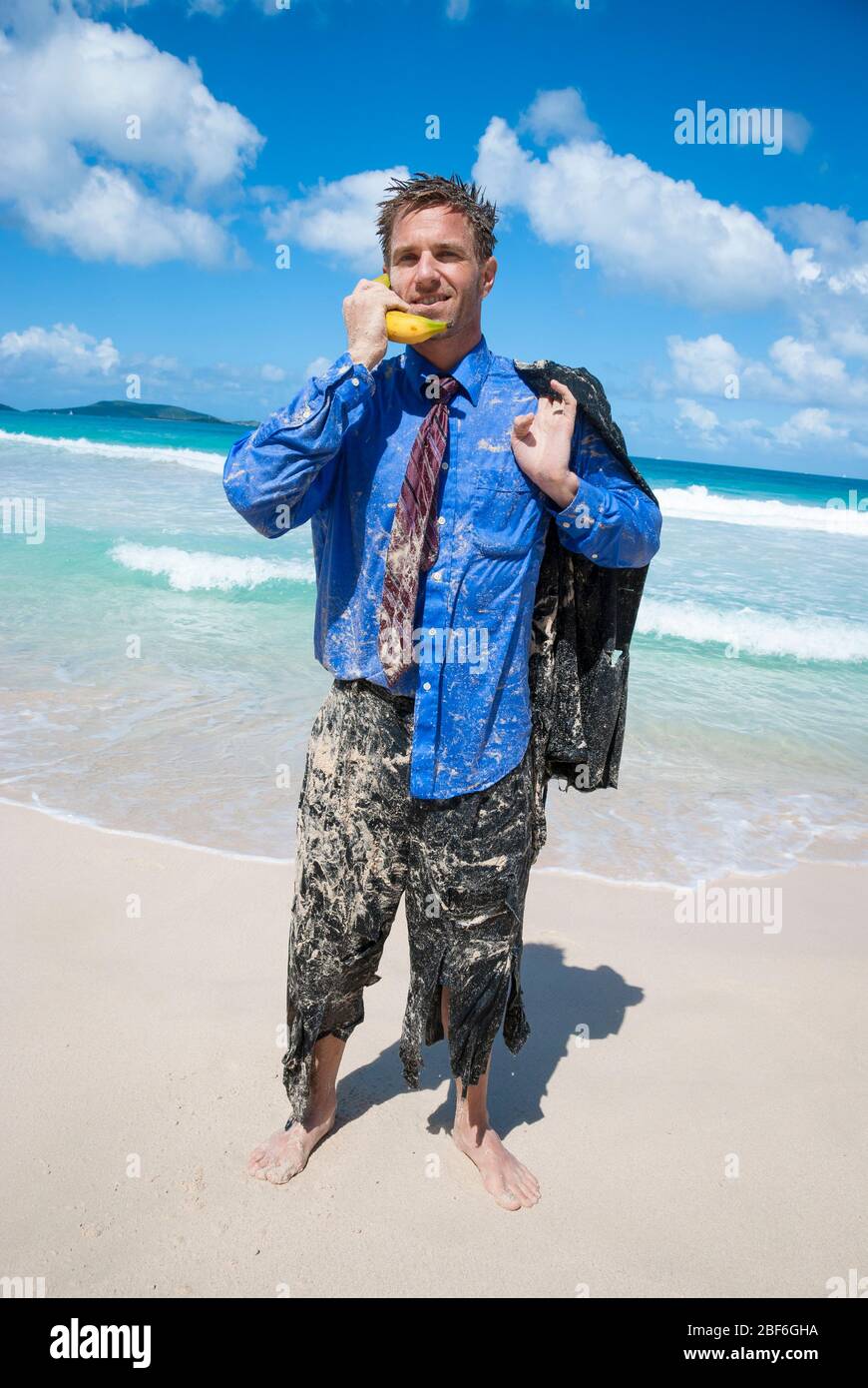 Castaway businessman using a banana as a mobile phone to have an ...