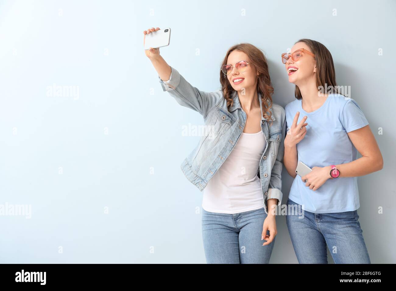 Young women taking selfie on color background Stock Photo - Alamy