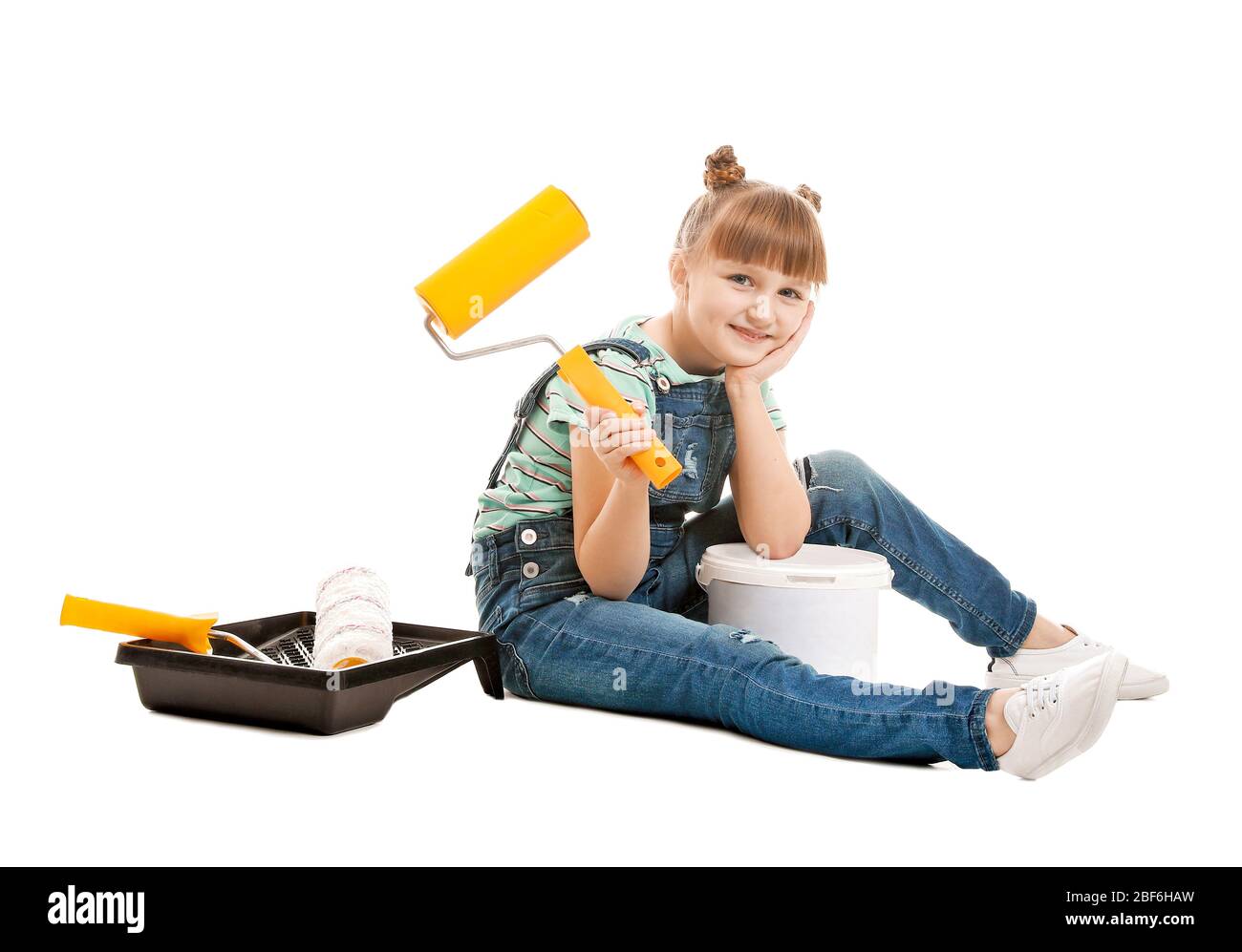 Little girl with paint tools on white background Stock Photo - Alamy