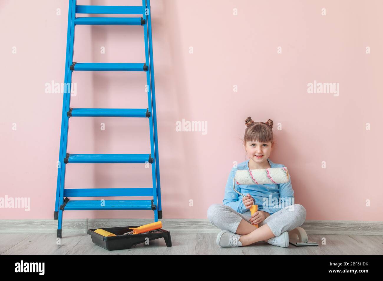 Little girl with painter tools in room Stock Photo - Alamy