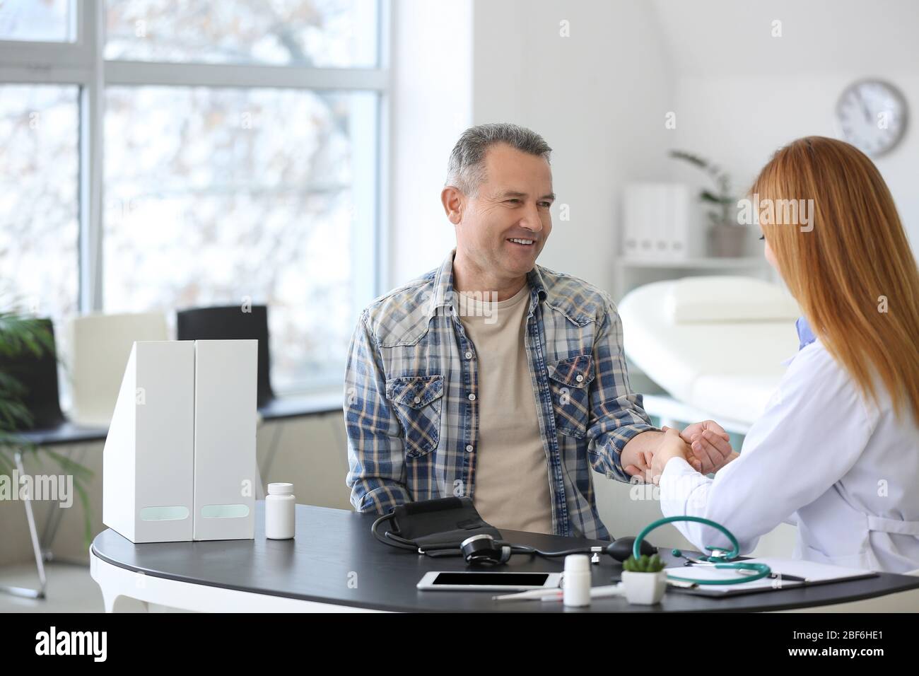 Mature man visiting doctor in clinic Stock Photo - Alamy