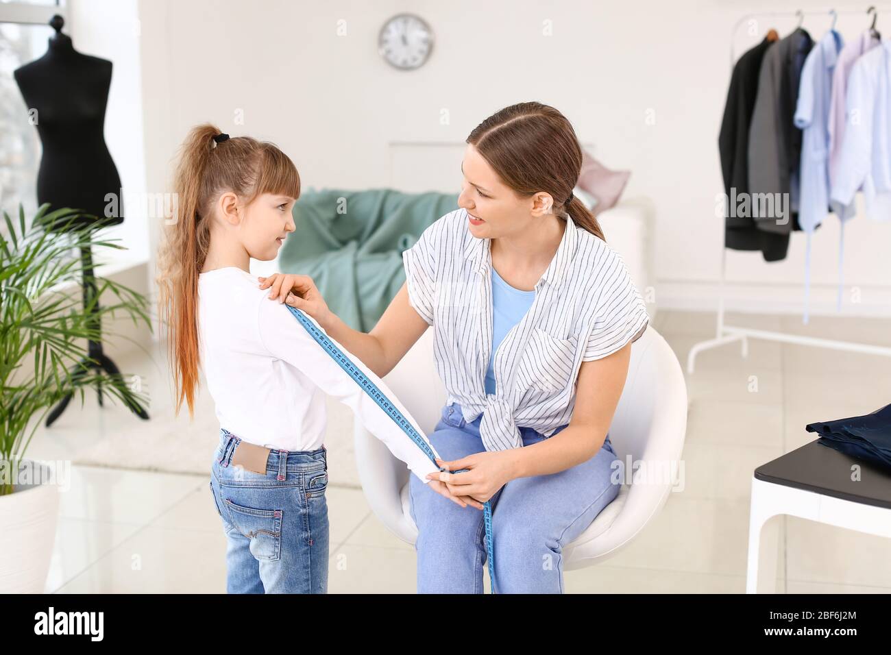 Female tailor working with little girl in atelier Stock Photo - Alamy