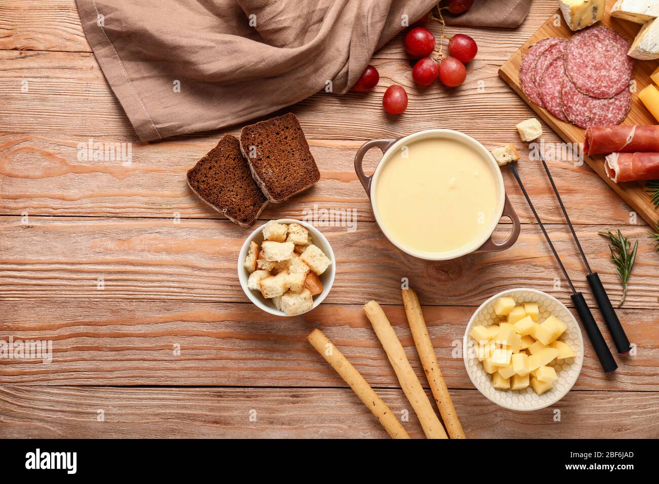 Cheese fondue with snacks on wooden background Stock Photo - Alamy