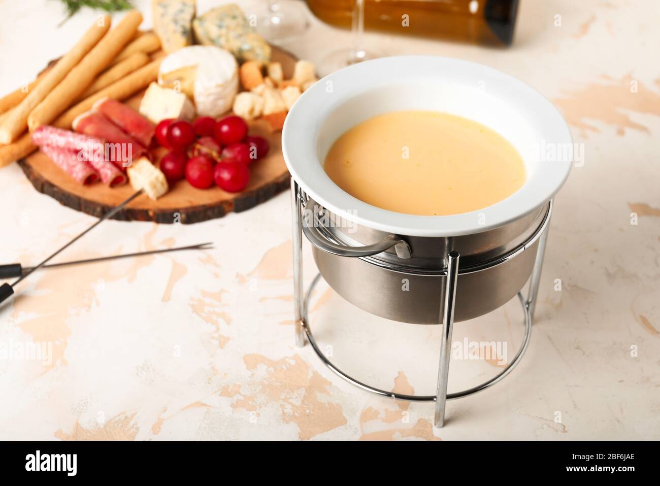 Cheese fondue with snacks on white background Stock Photo - Alamy