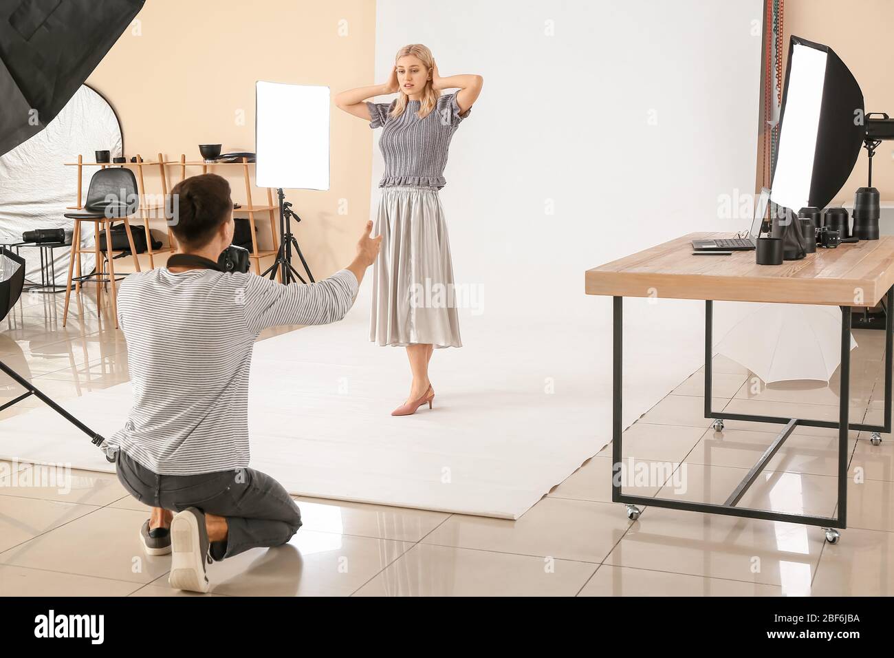 Professional photographer working with model in studio Stock Photo - Alamy