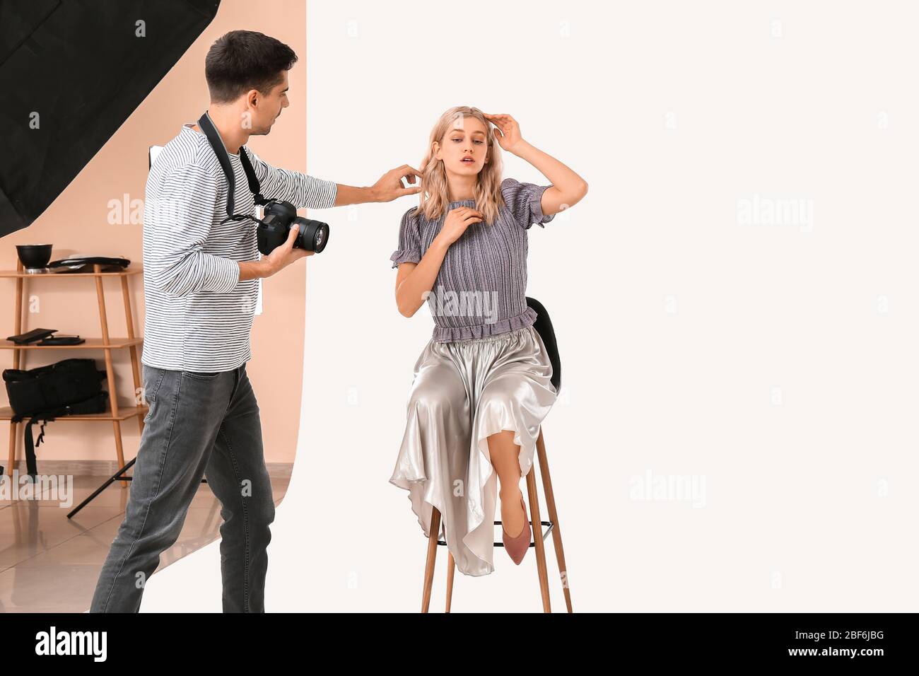 Professional photographer working with model in studio Stock Photo - Alamy