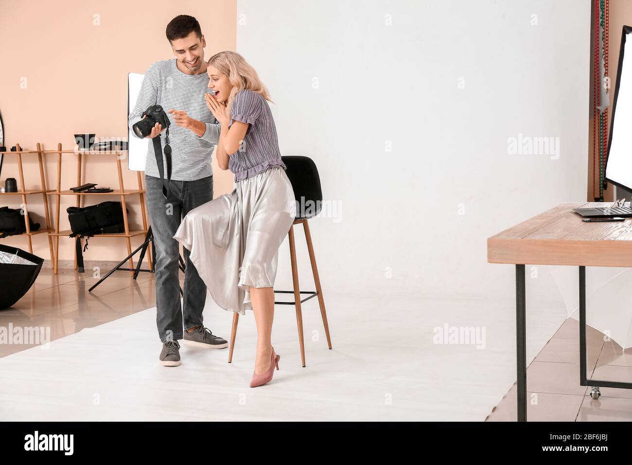 Professional photographer showing pictures to model in studio Stock ...