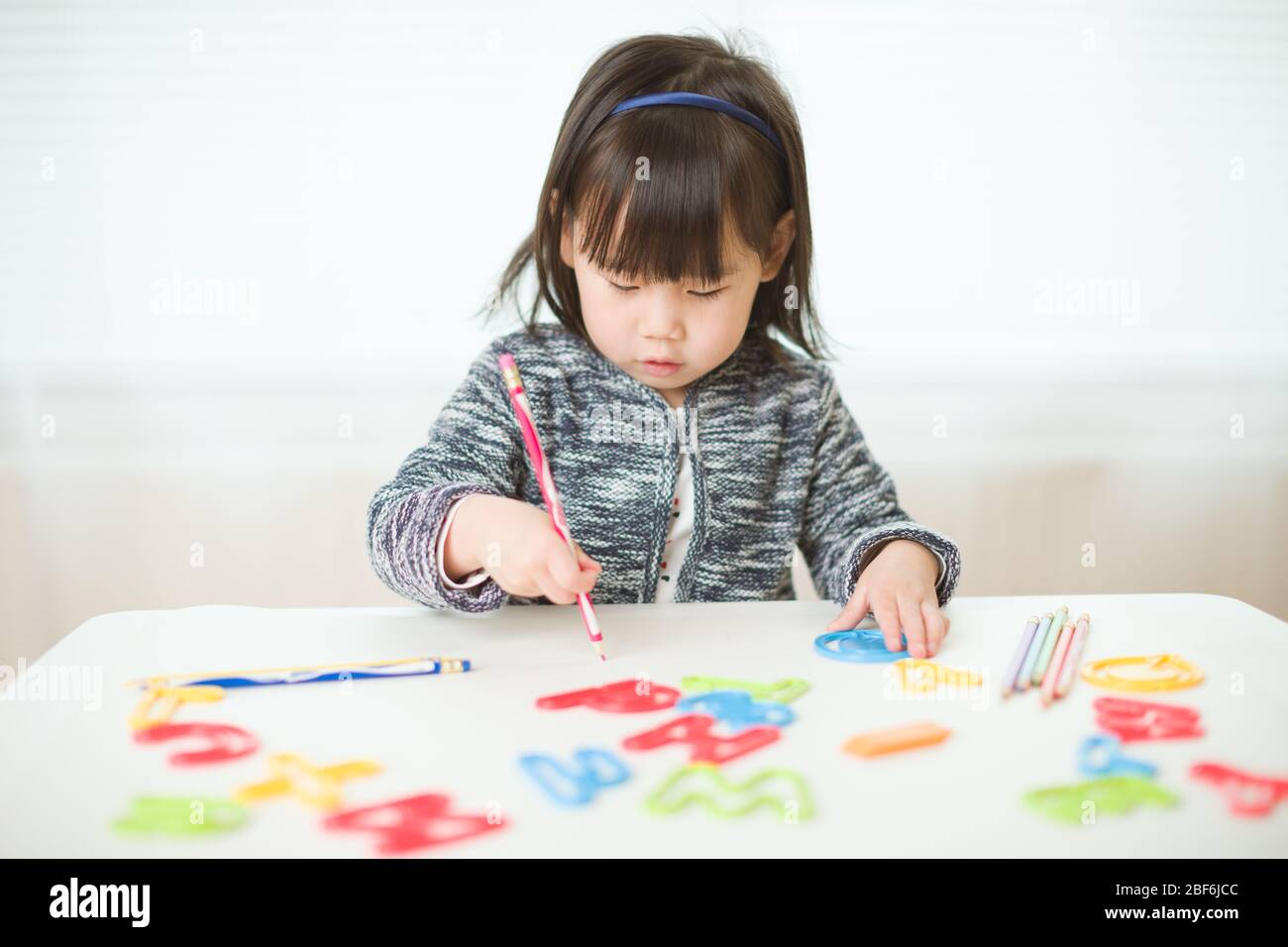 toddler girl practice writing letters for homeschooling Stock Photo - Alamy
