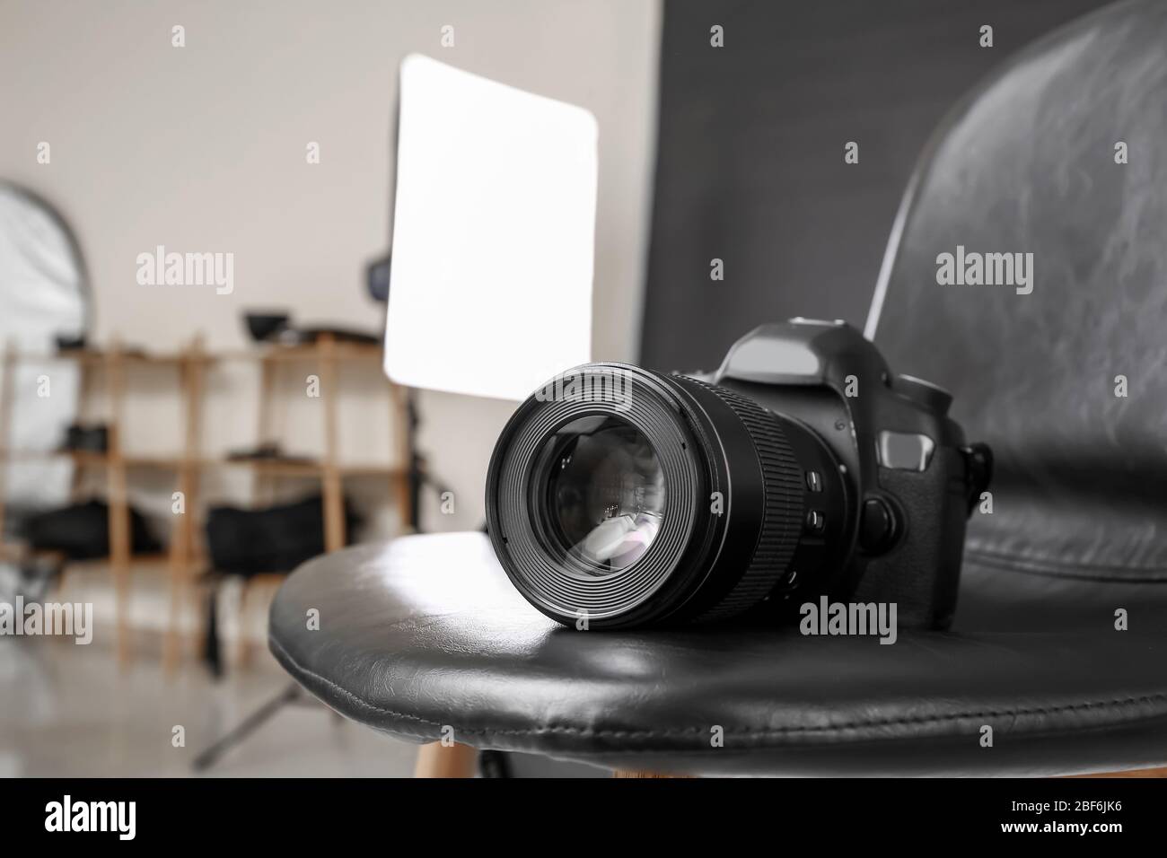 Modern camera on chair in professional photo studio Stock Photo - Alamy