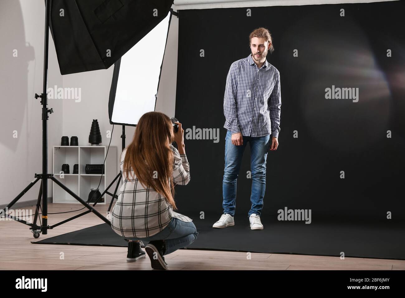 Professional photographer working with model in studio Stock Photo - Alamy