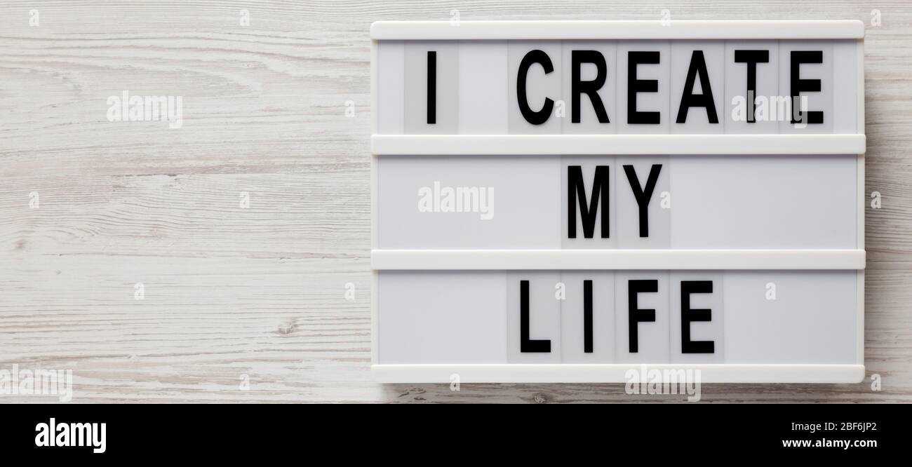 'I create my life' words on a lightbox on a white wooden surface, top ...
