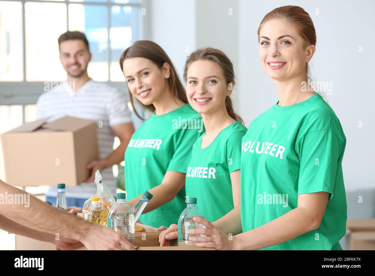 Team of volunteers giving products to poor people Stock Photo - Alamy