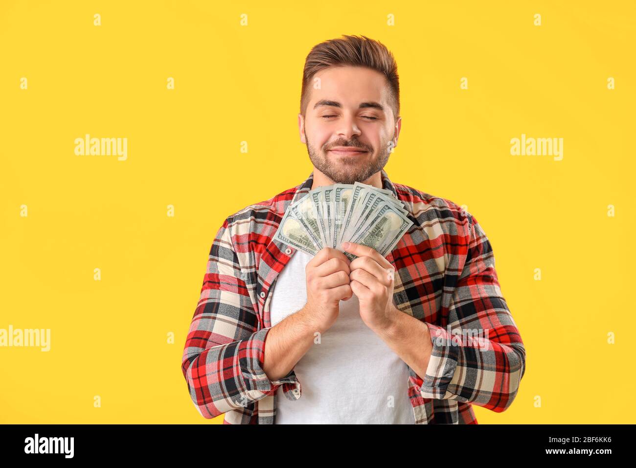 Happy man with money on color background Stock Photo - Alamy
