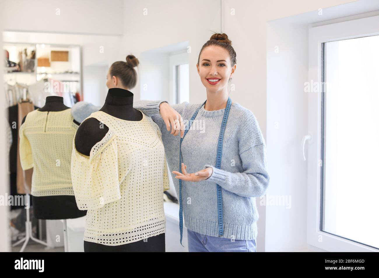 Female tailor near mannequin with clothes in workshop Stock Photo - Alamy
