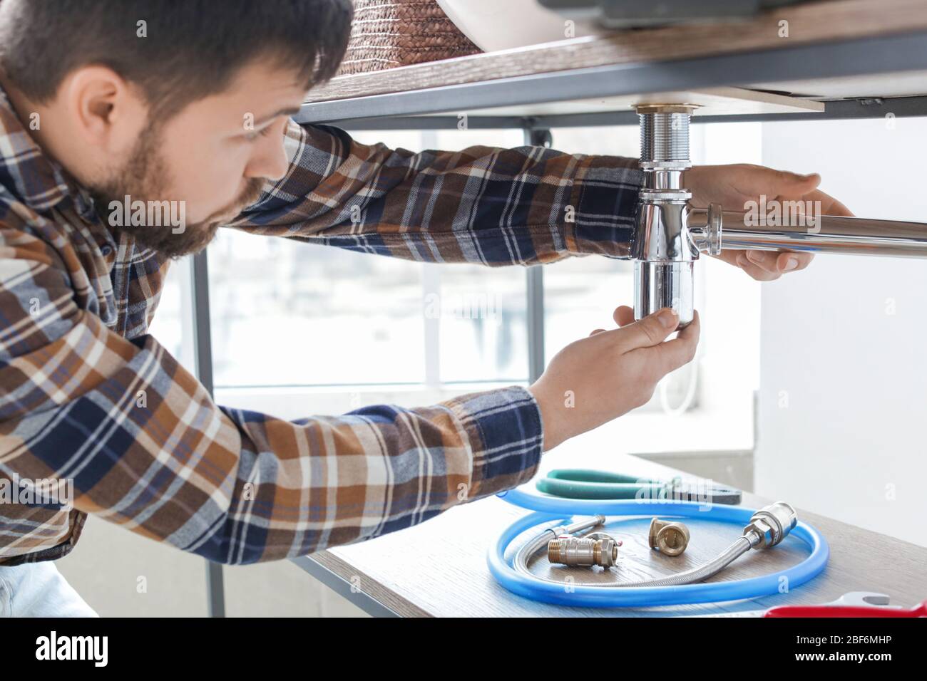 Handsome plumber repairing drain sink hi-res stock photography and ...