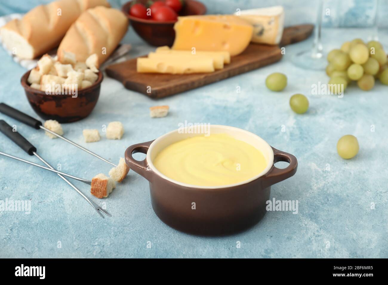 Cheese fondue with snacks on color background Stock Photo - Alamy