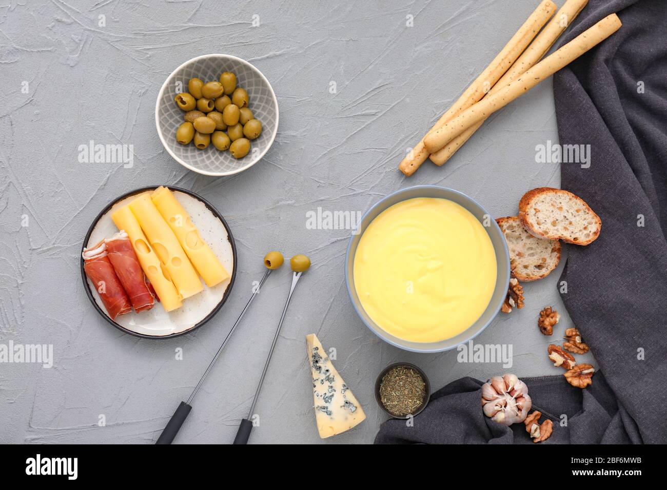 Cheese fondue with snacks on grey background Stock Photo - Alamy