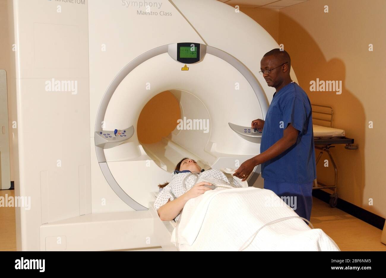 A female patient lies on the examination table of a magnetic resonance ...