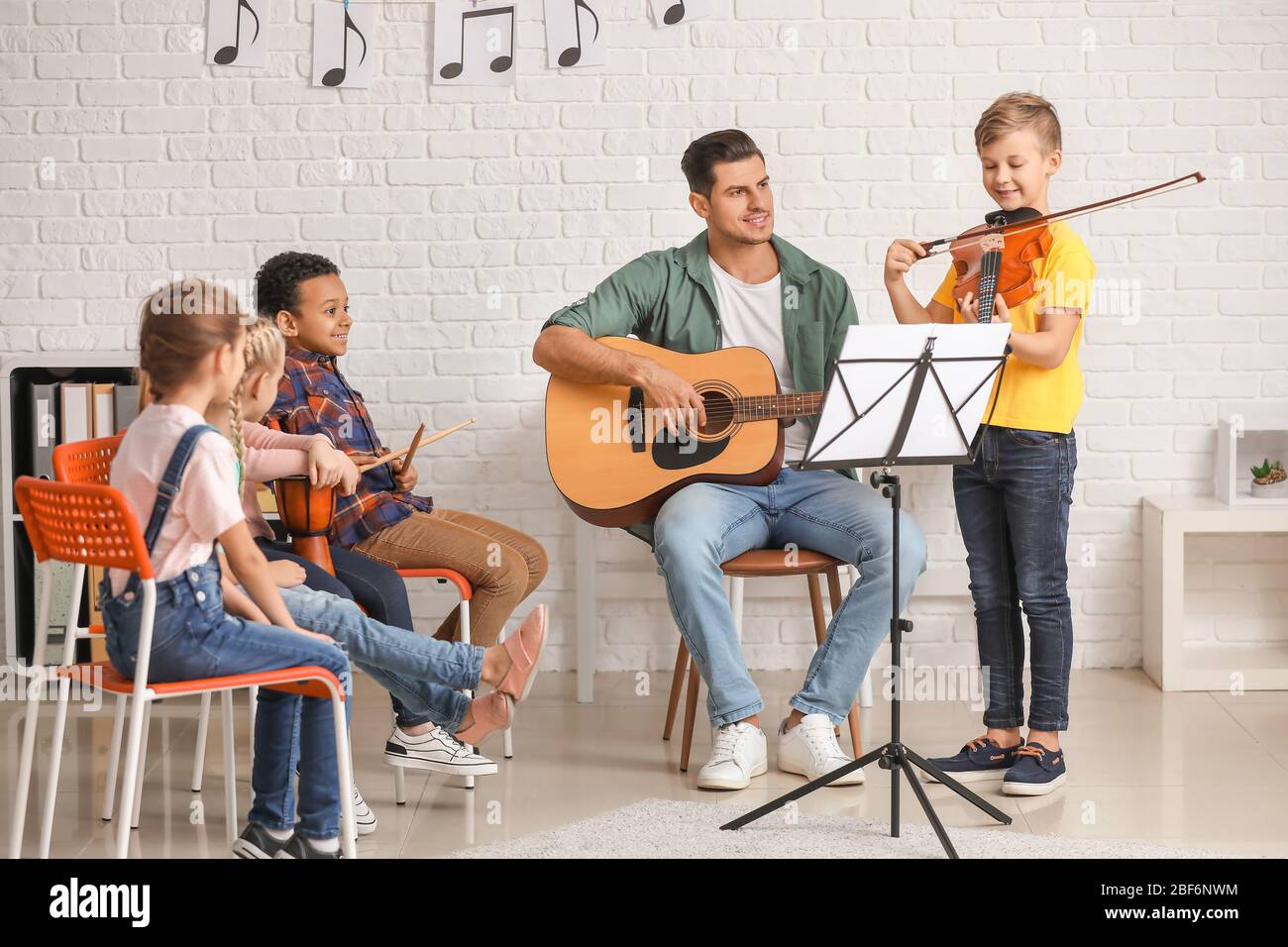 Teacher giving music lessons at school Stock Photo - Alamy