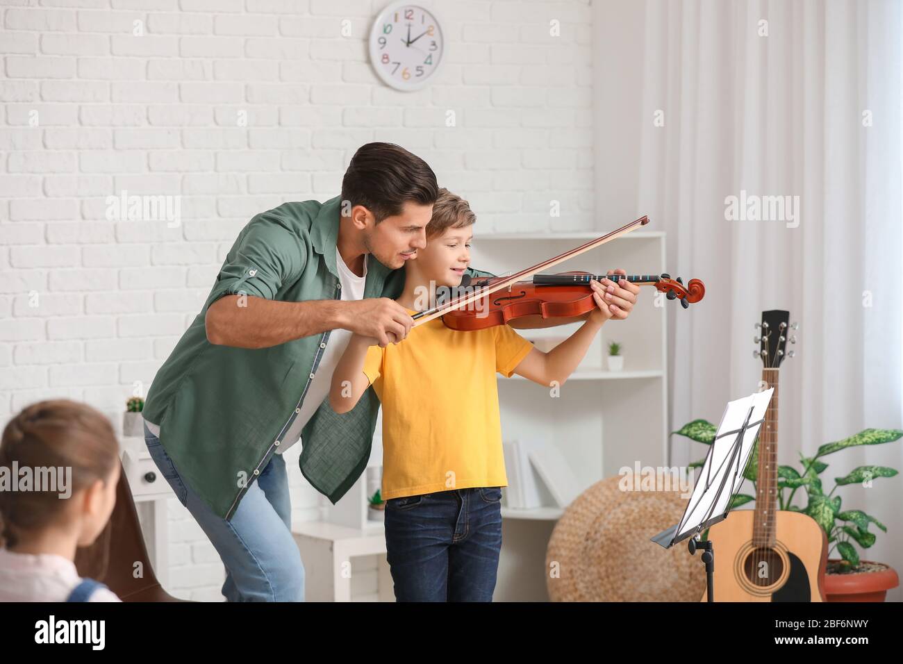 Teacher giving music lessons at school Stock Photo - Alamy