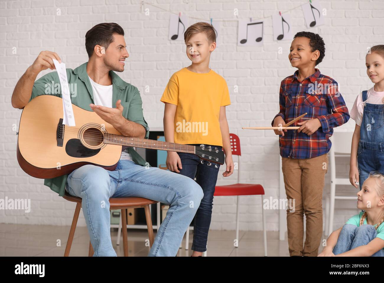 Teacher giving music lessons at school Stock Photo - Alamy