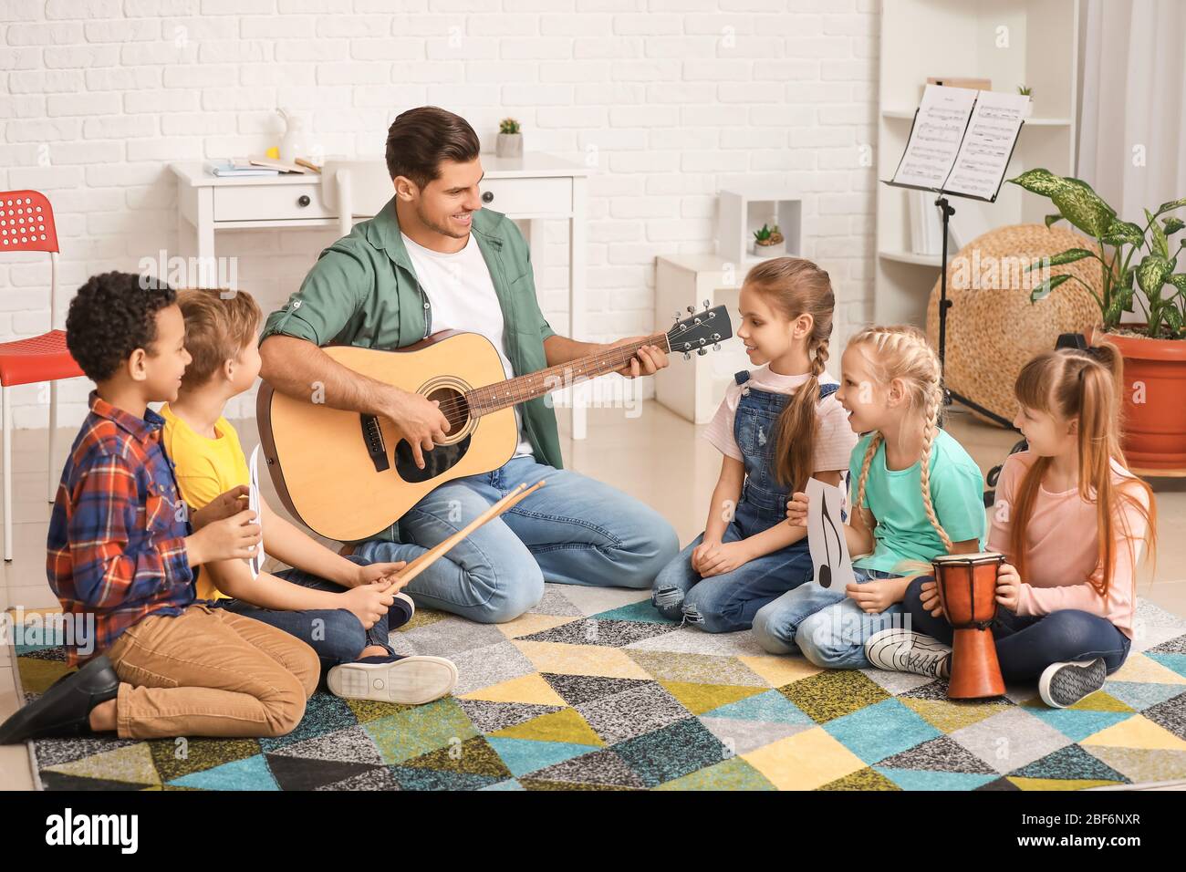 Teacher giving music lessons at school Stock Photo - Alamy