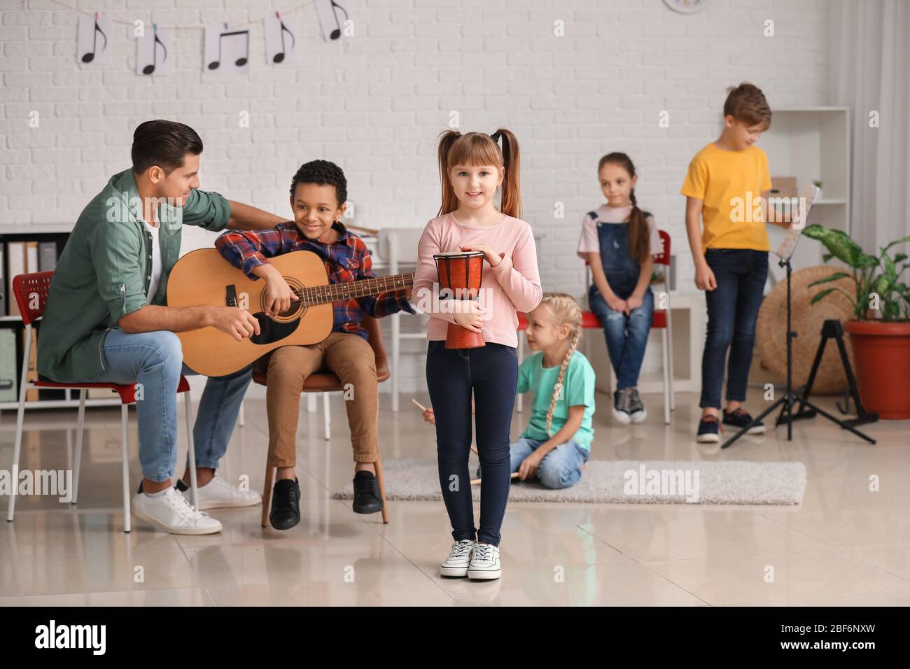 Teacher giving music lessons at school Stock Photo - Alamy