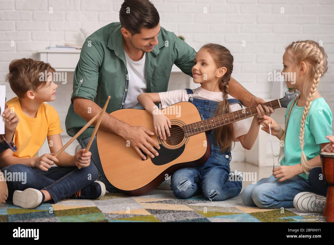 Teacher giving music lessons at school Stock Photo - Alamy