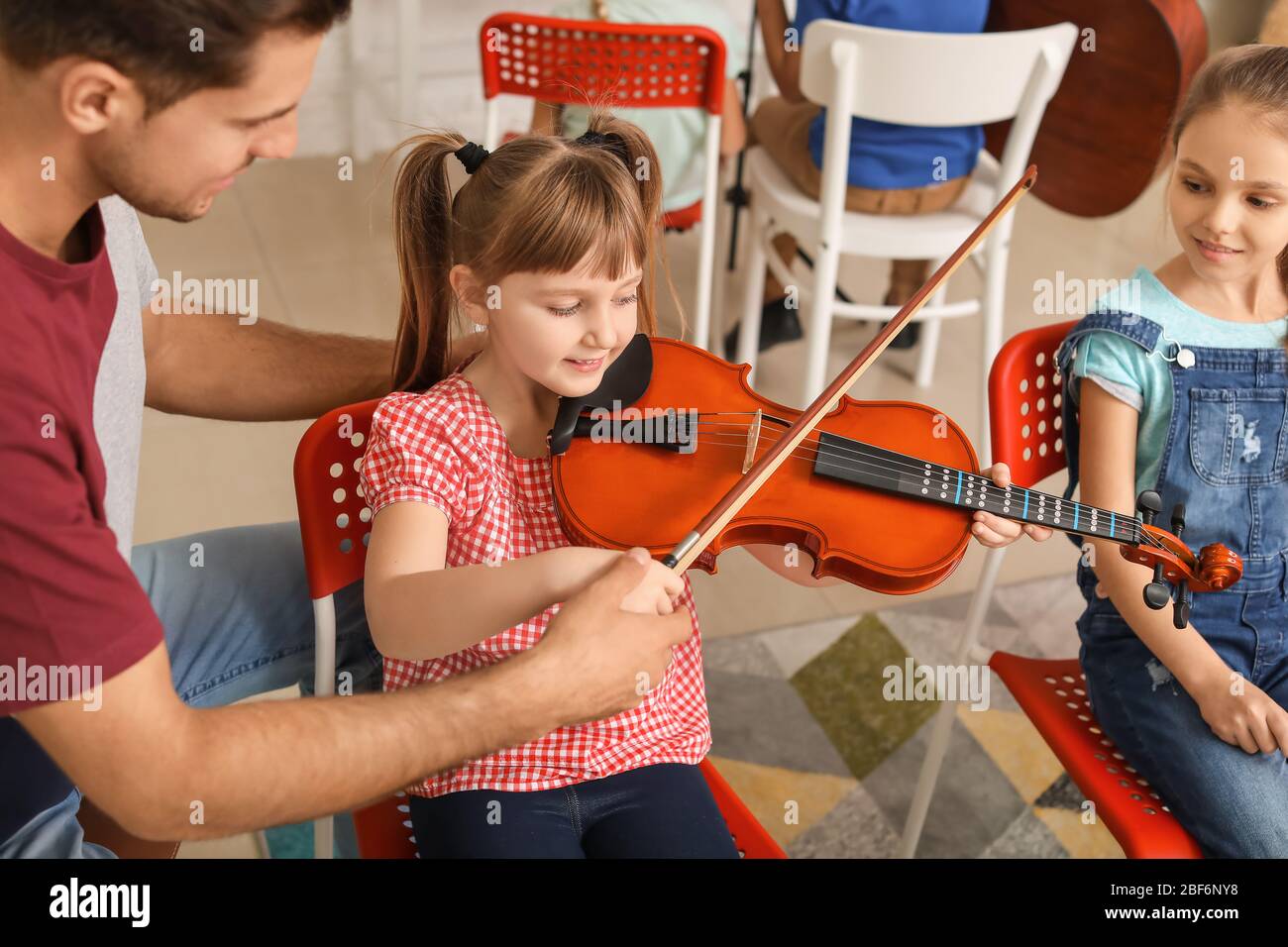 Teacher giving music lessons at school Stock Photo - Alamy