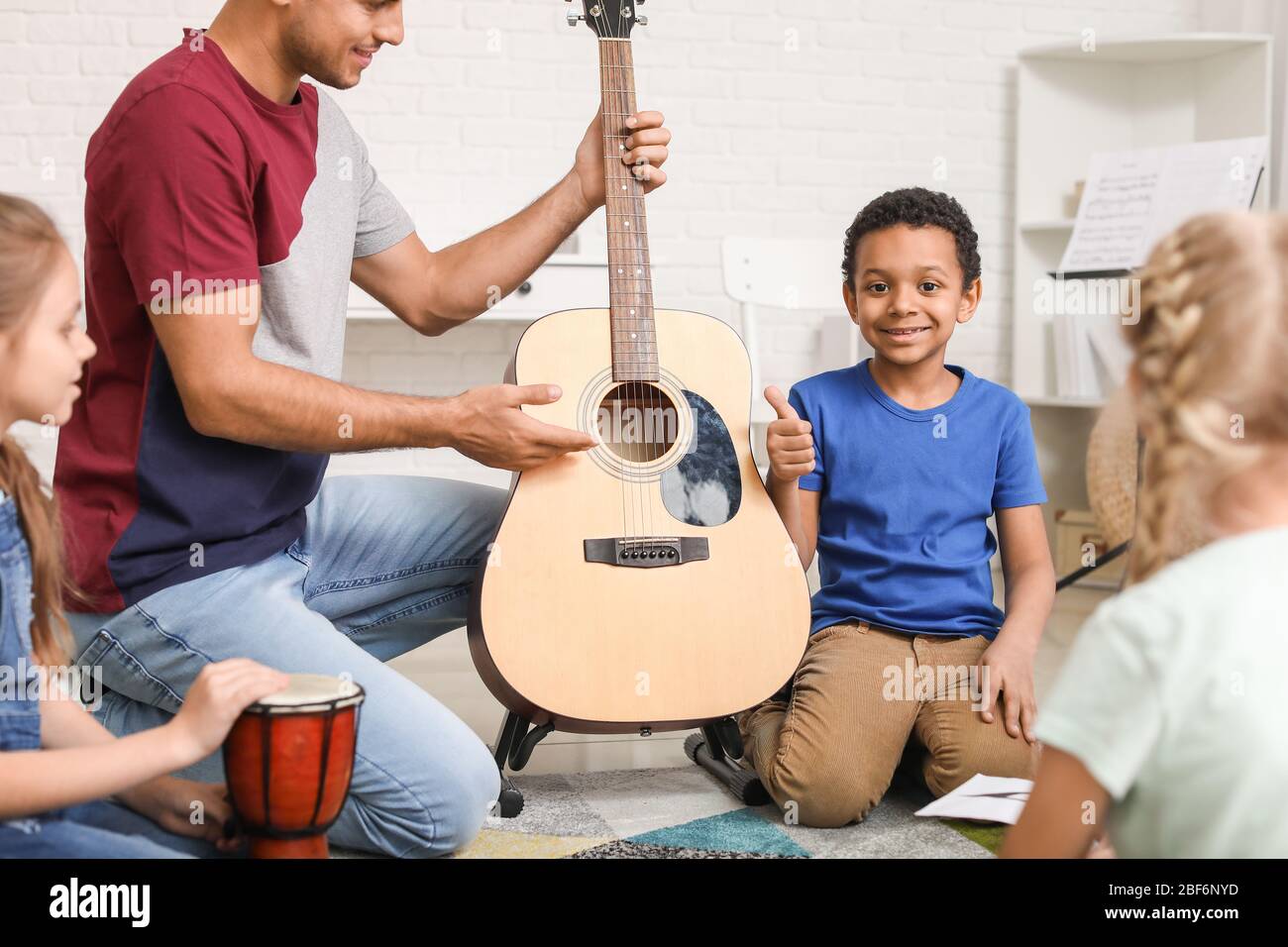 Teacher giving music lessons at school Stock Photo - Alamy