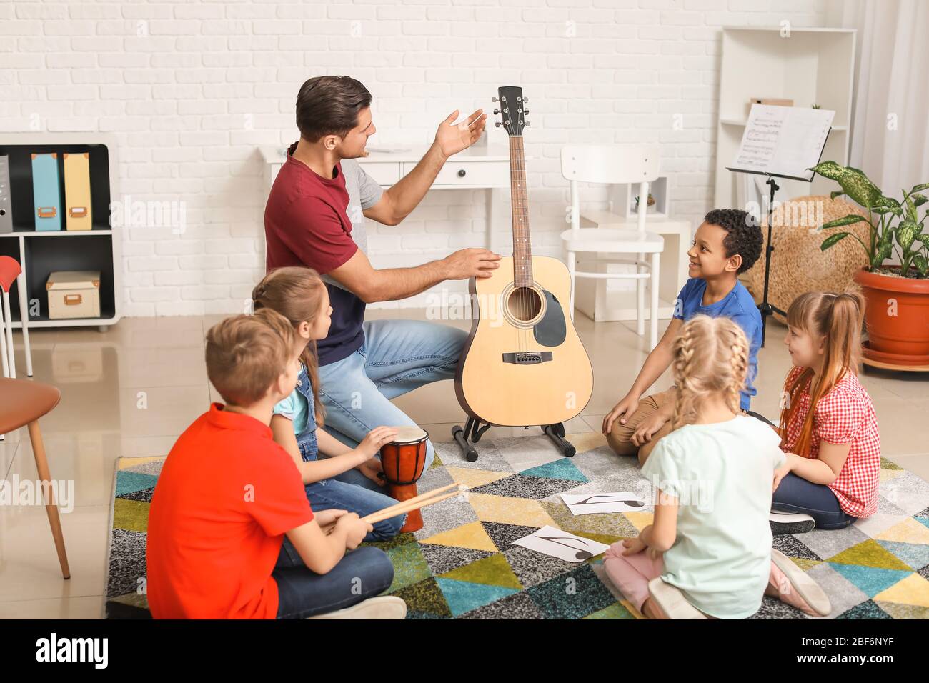 Teacher giving music lessons at school Stock Photo - Alamy