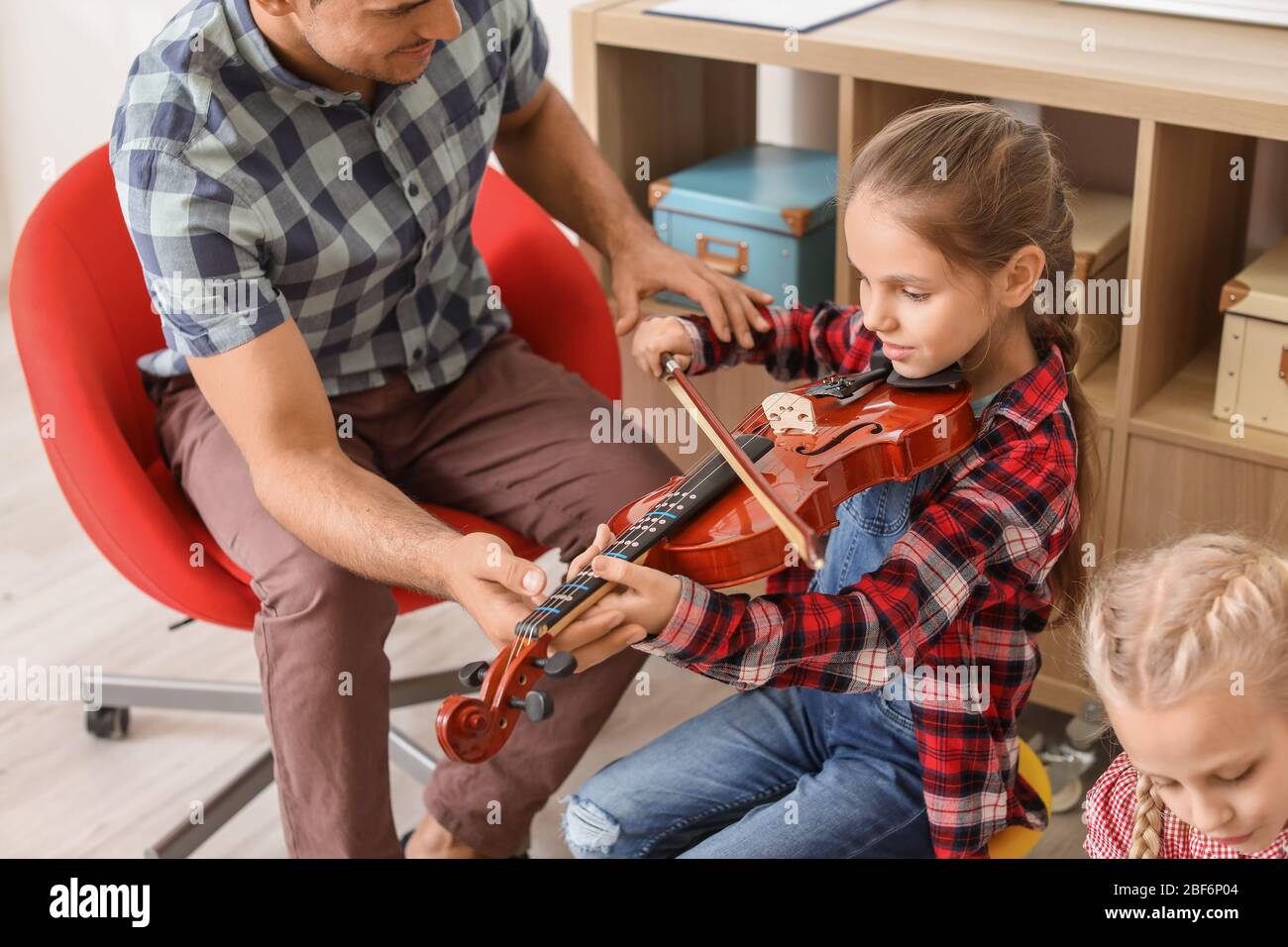Teacher giving music lessons at school Stock Photo - Alamy