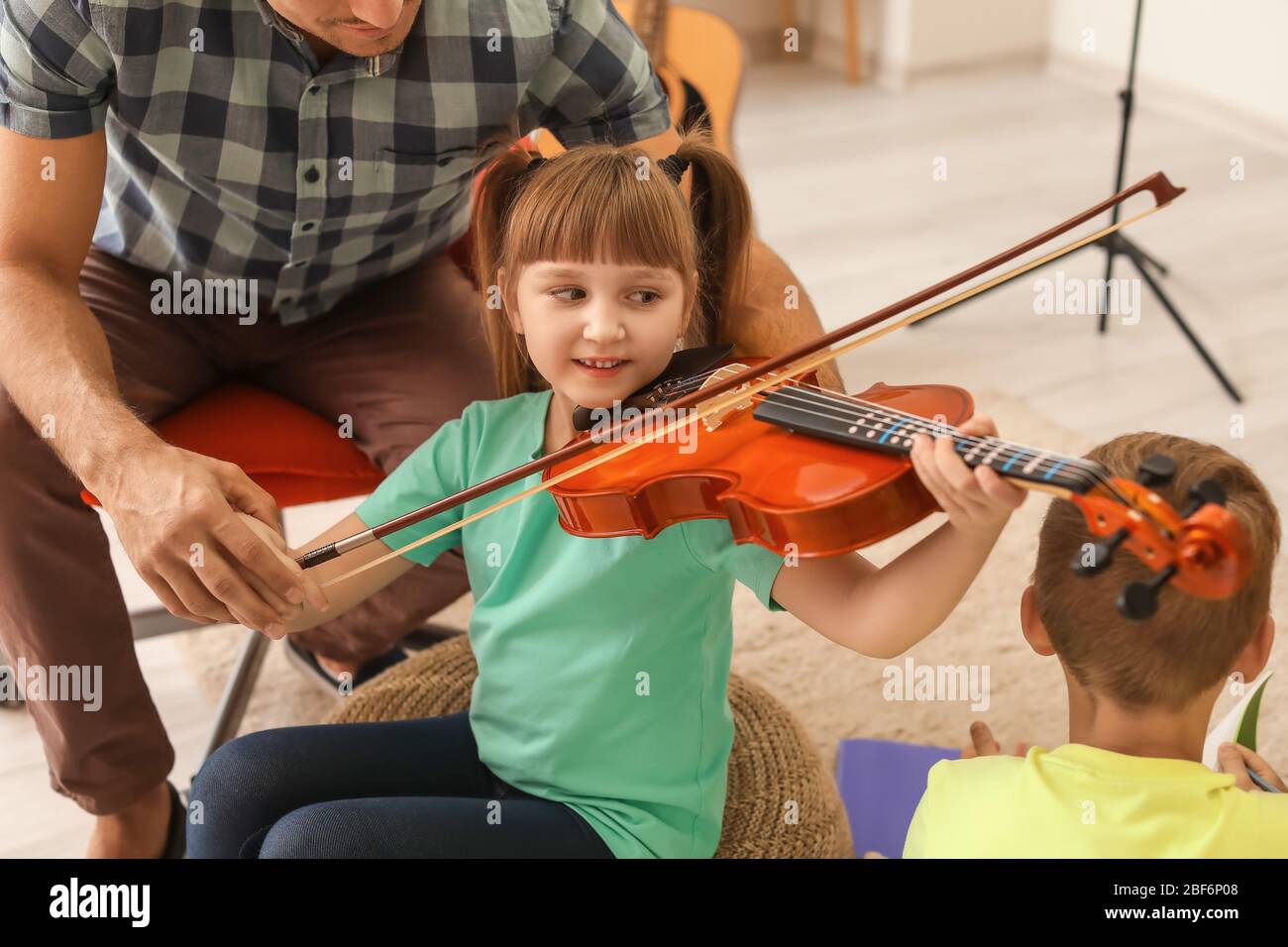 Teacher giving music lessons at school Stock Photo - Alamy