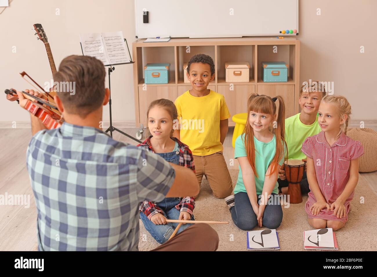 Teacher giving music lessons at school Stock Photo - Alamy