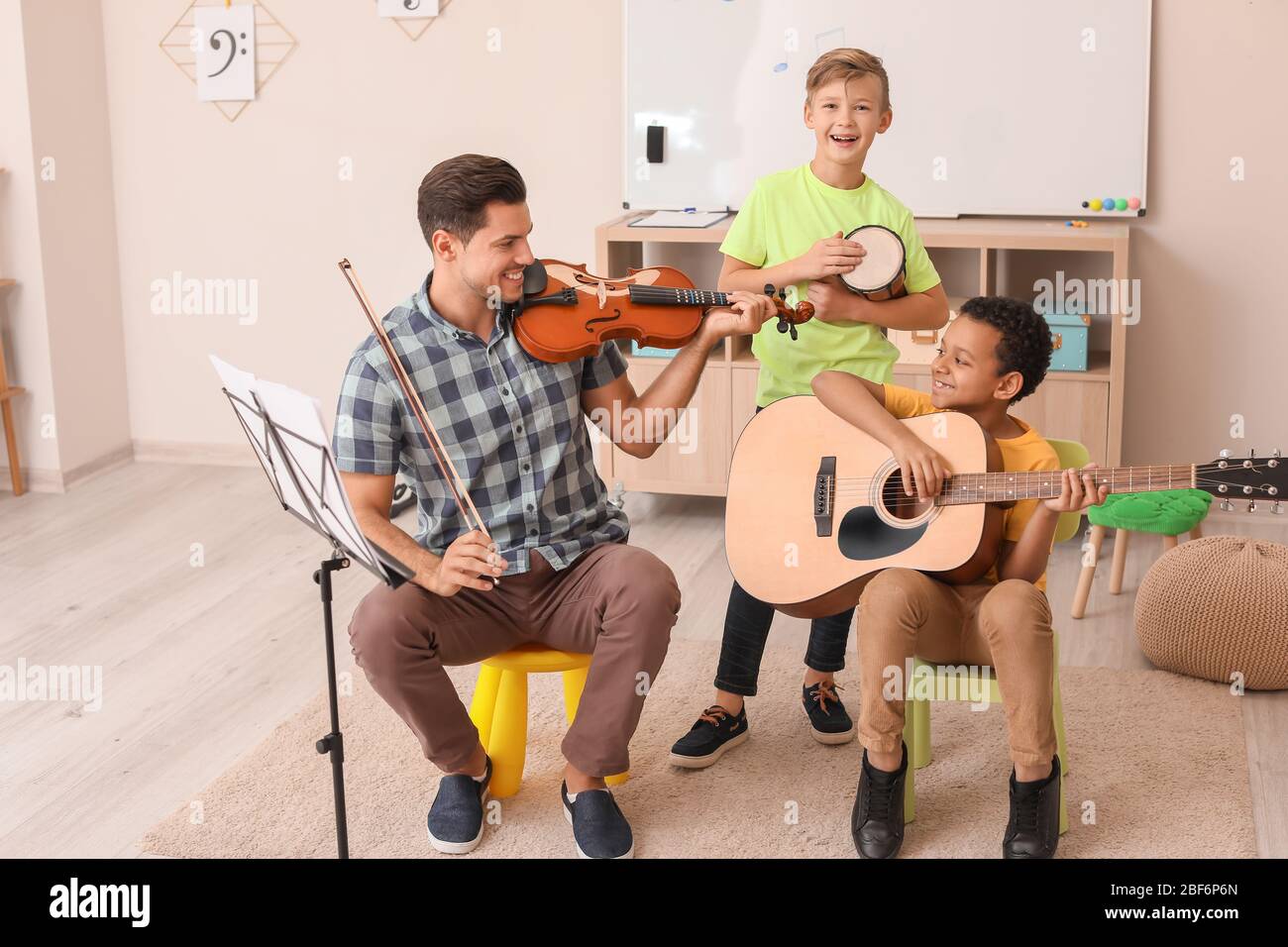 Teacher giving music lessons at school Stock Photo - Alamy