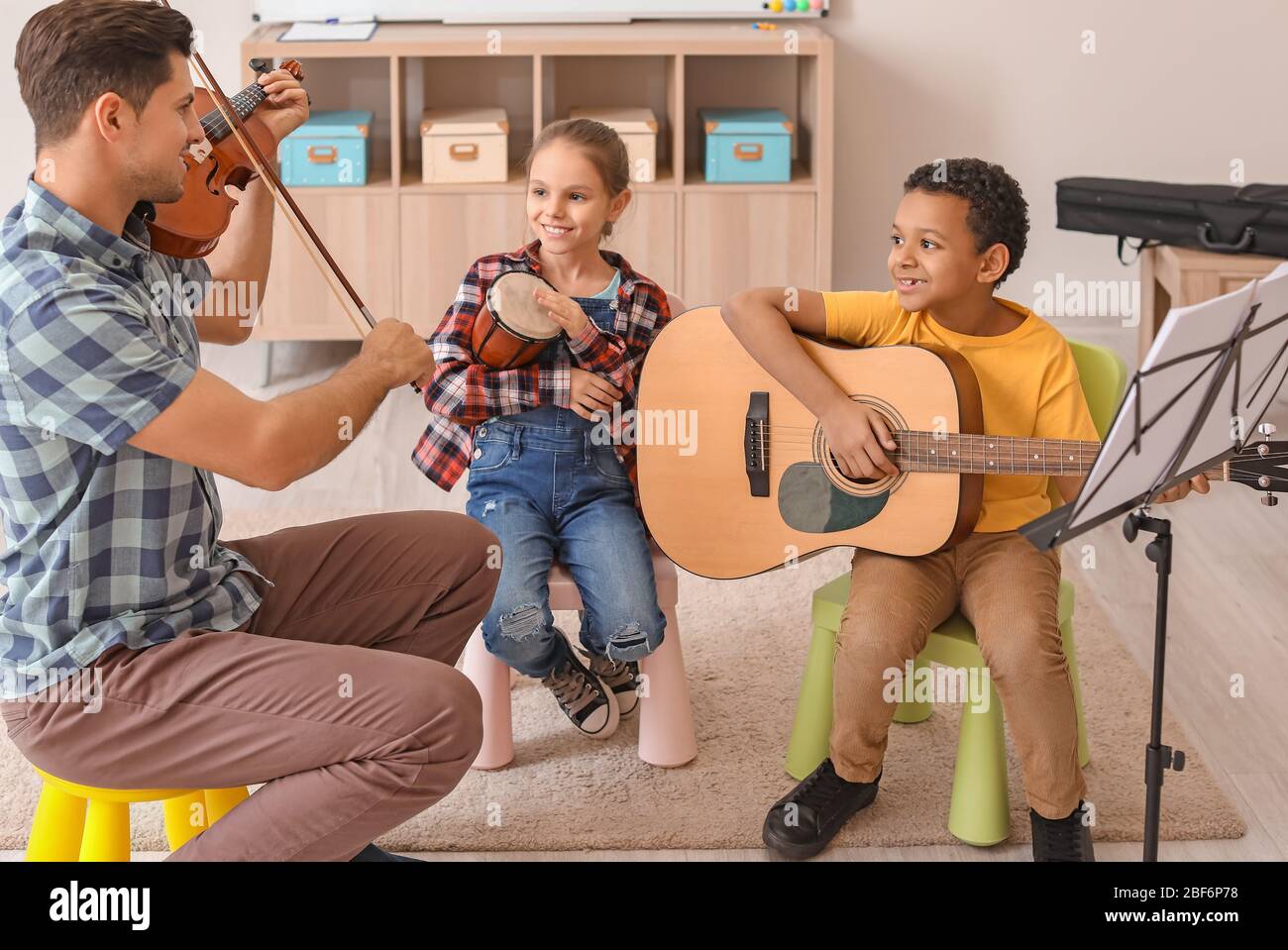Teacher giving music lessons at school Stock Photo - Alamy