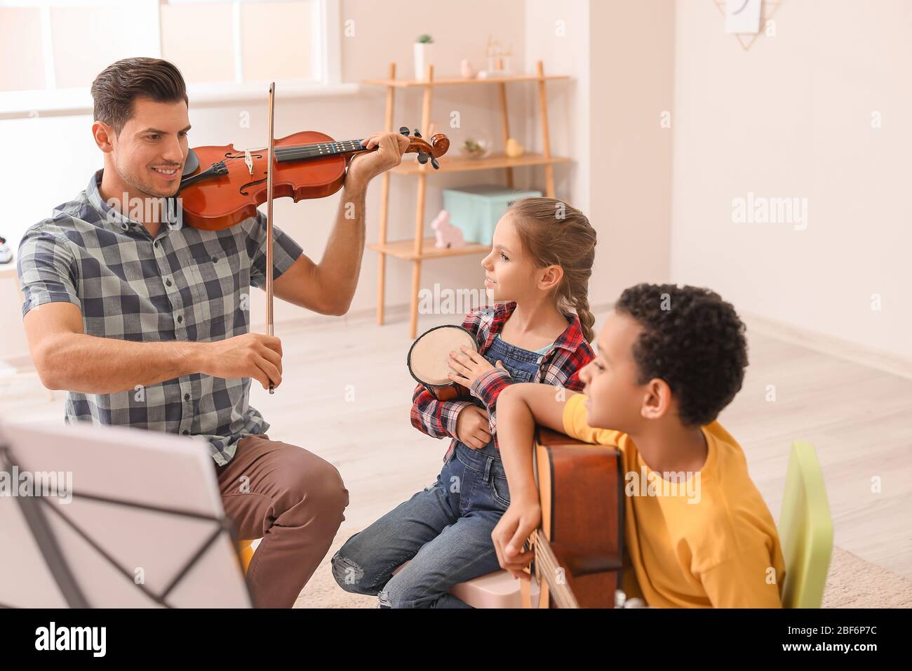 Teacher giving music lessons at school Stock Photo - Alamy
