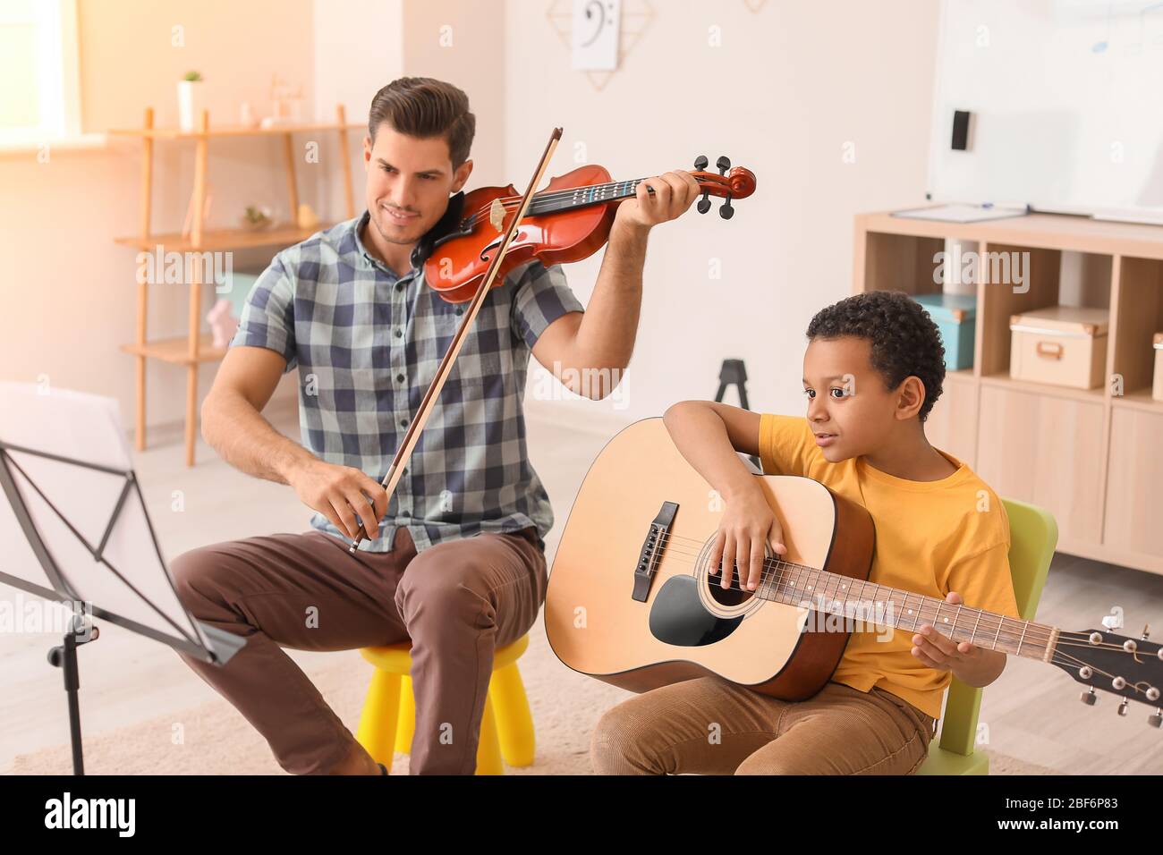 Teacher giving music lessons at school Stock Photo - Alamy