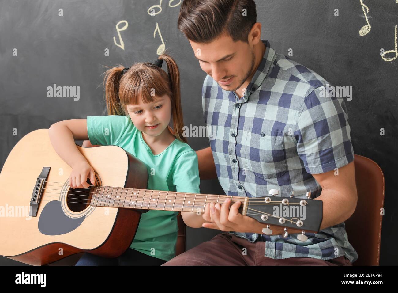 Teacher giving music lessons at school Stock Photo - Alamy