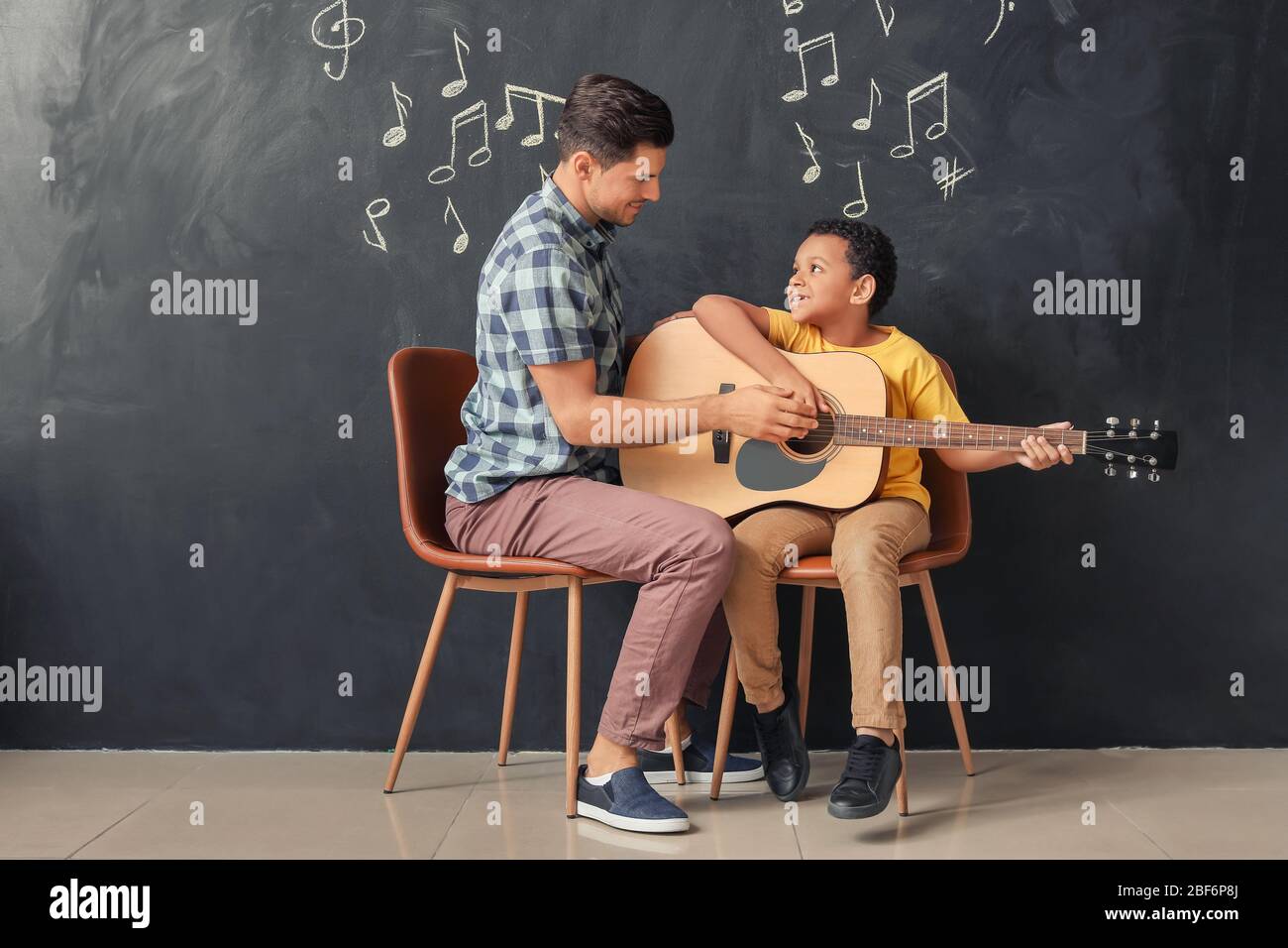 Teacher giving music lessons at school Stock Photo - Alamy