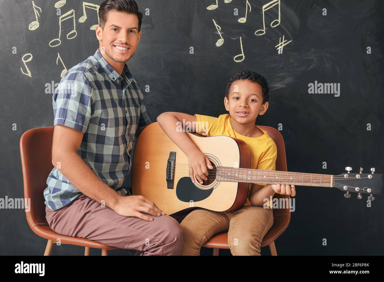 Teacher giving music lessons at school Stock Photo - Alamy