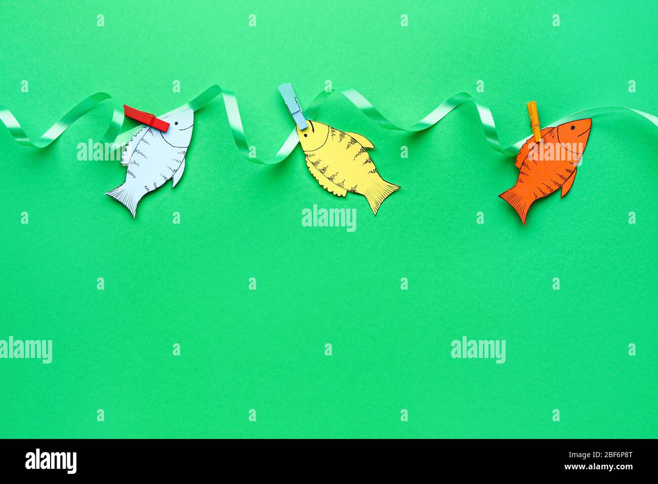 Paper fishes on color background. April Fool's Day prank Stock Photo ...