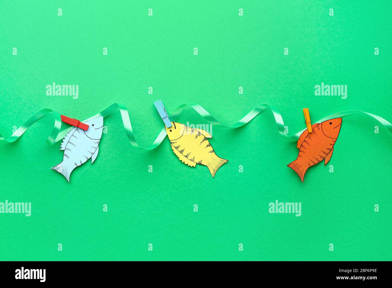 Paper fishes on color background. April Fool's Day prank Stock Photo ...