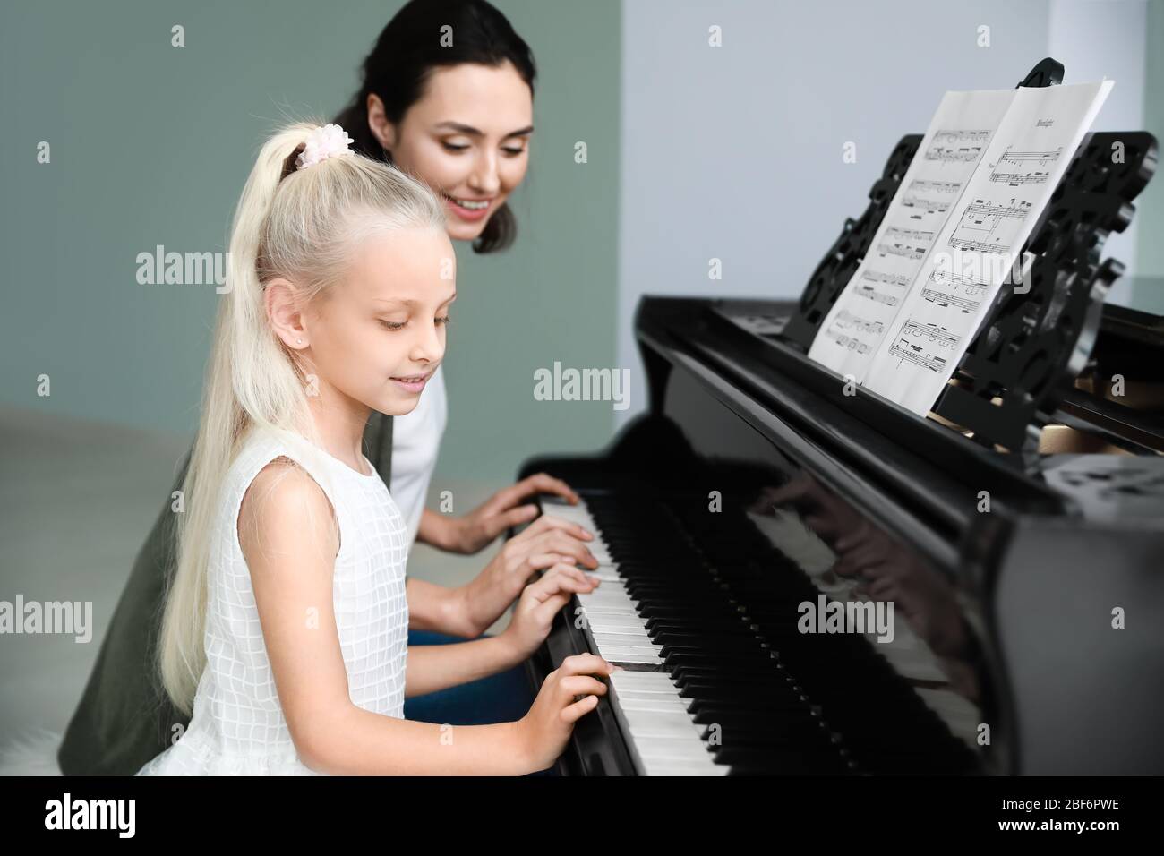 Private music teacher giving piano lessons to little girl Stock Photo ...