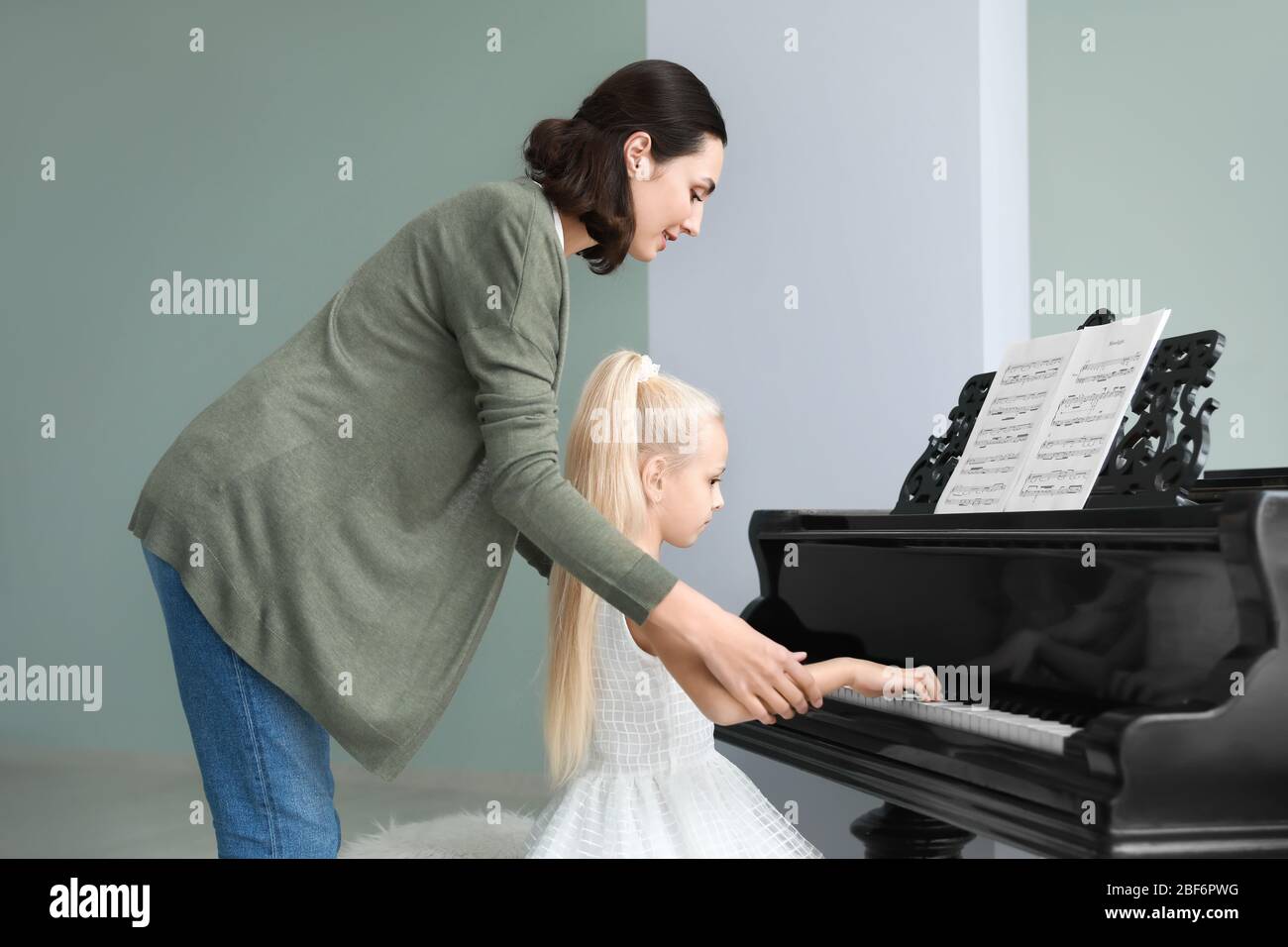 Private music teacher giving piano lessons to little girl Stock Photo ...