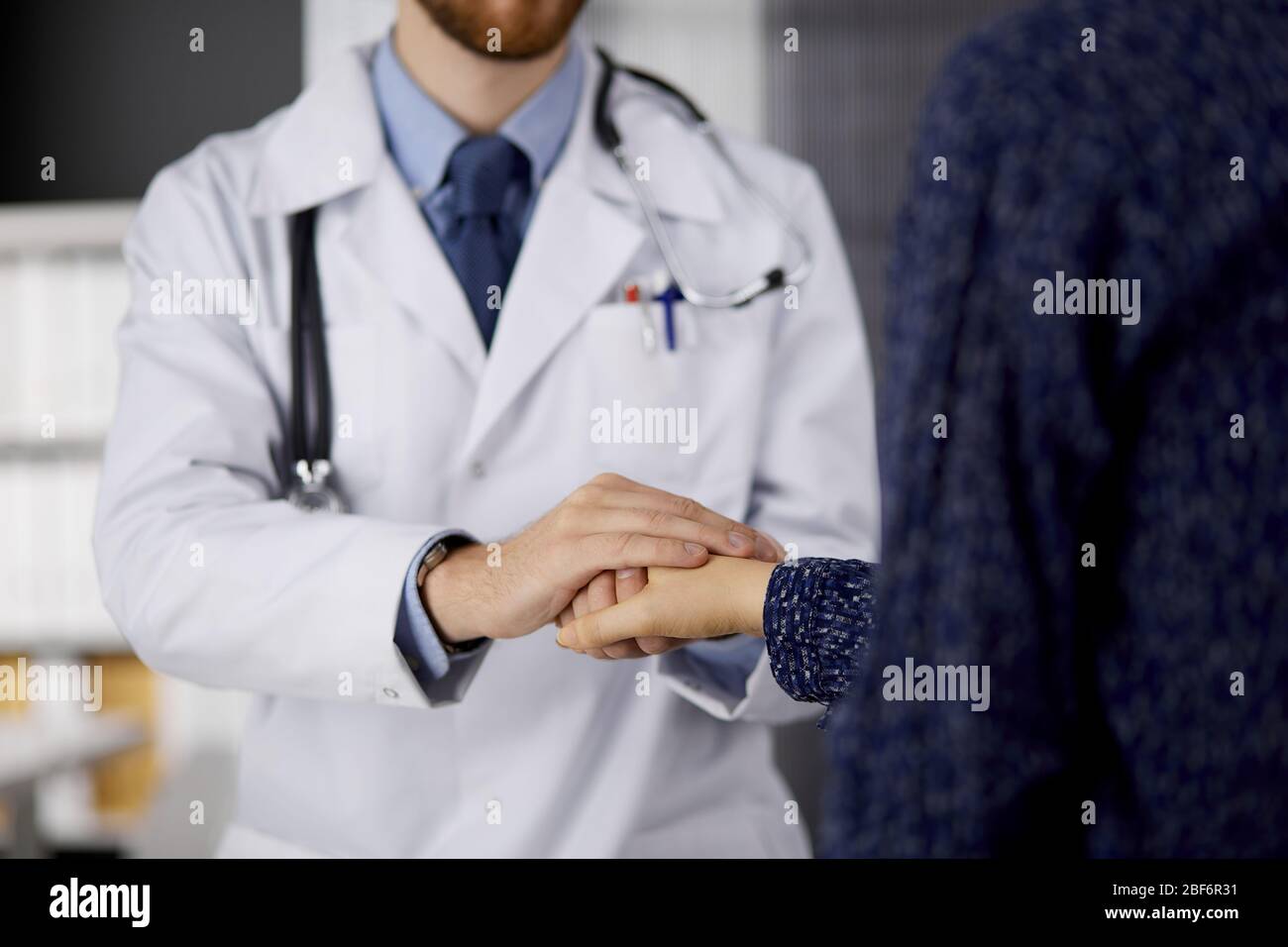 Friendly red-beard doctor reassuring his female patient, close-up ...