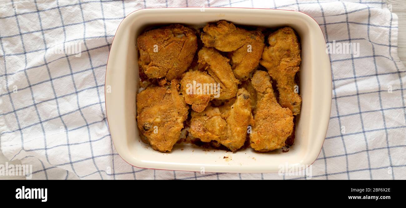 Crispy homemade oven baked fried chicken in a dish on cloth, top view ...