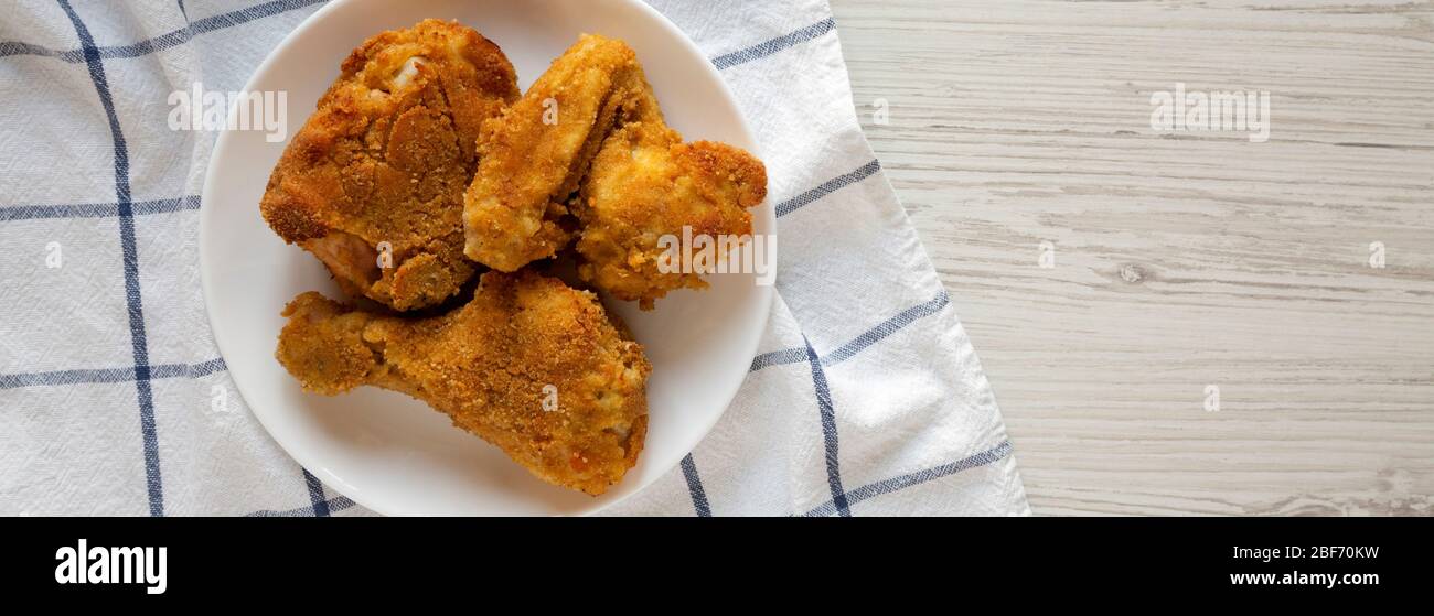 Tasty homemade oven baked fried chicken on a white plate, overhead view ...