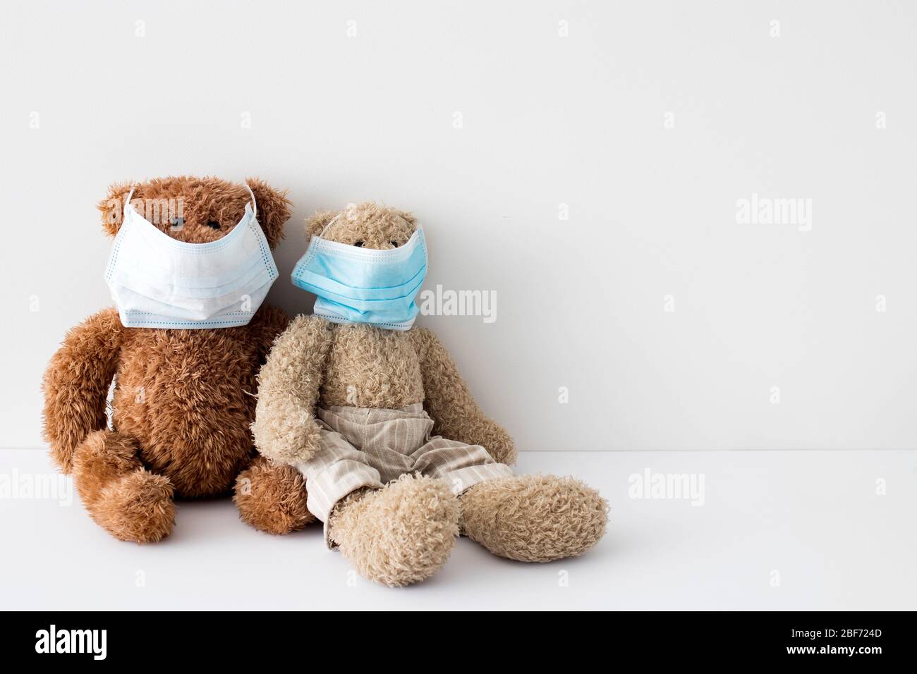 Two teddy bears in medical masks on white background. The concept of ...