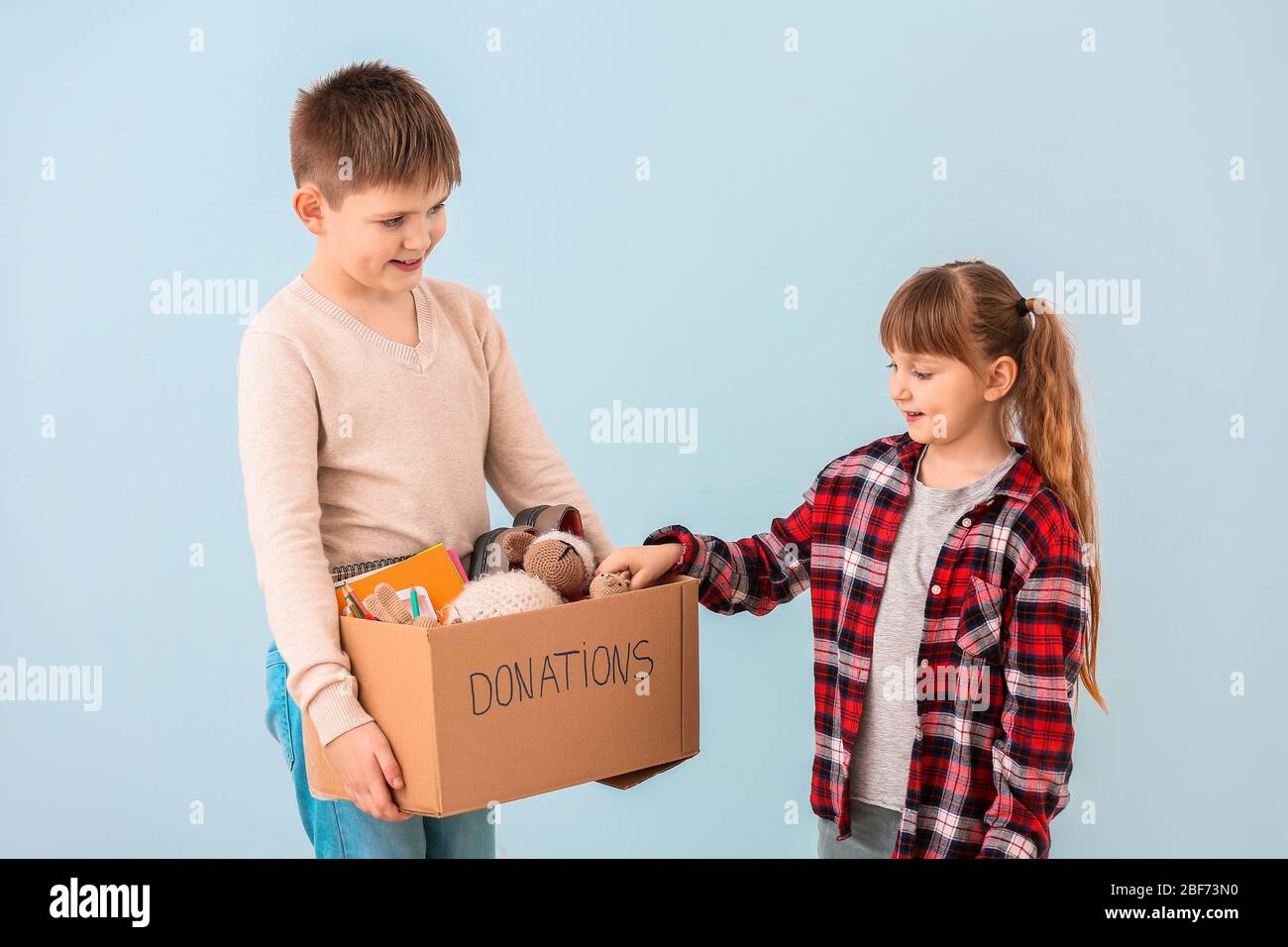 Little children with donations on color background Stock Photo - Alamy